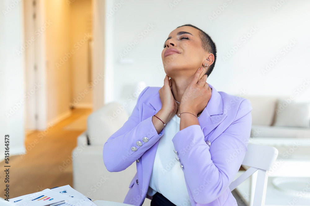 Businesswoman feeling pain in neck after sitting at the table with ...