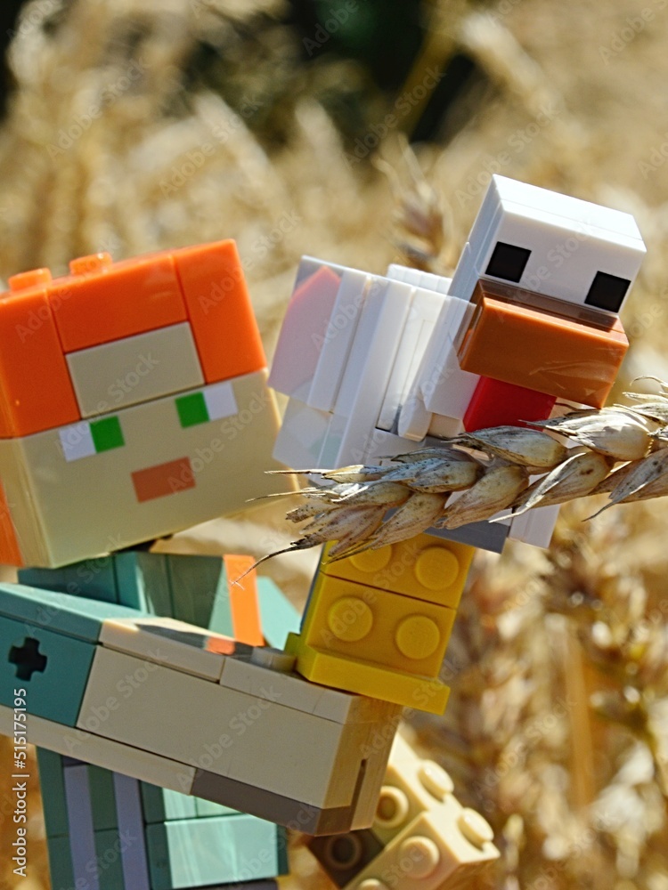 LEGO Minecraft figure of Alex feeding hen with mature grains of wheat directly on sunlit ...