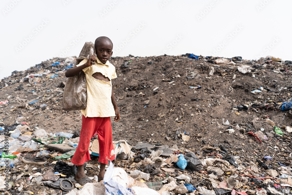 Foto de Stock Poor dirty African child working in a landfill with some ...
