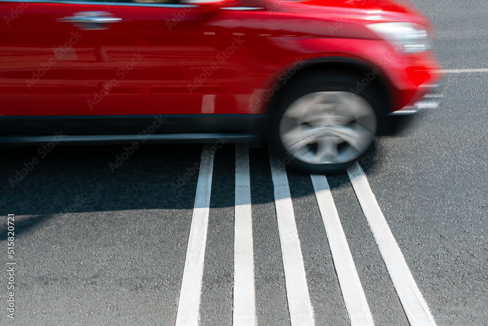 Rumble strips or speed breakers on asphalt road surface and red car ...