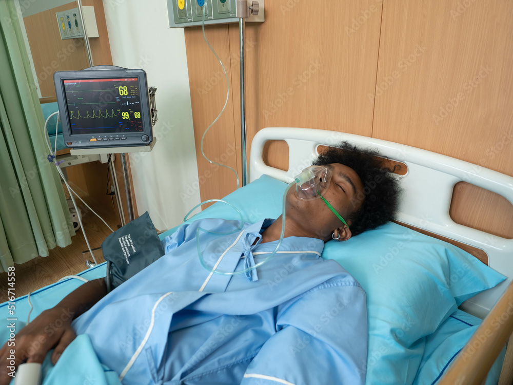 At hospital intensive care unit patient in coma lay on bed ...