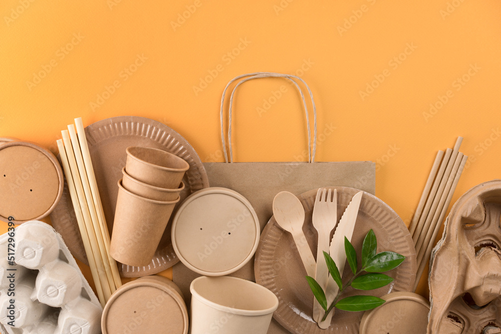 Eco-friendly paper utensils - kraft paper food packaging over orange ...