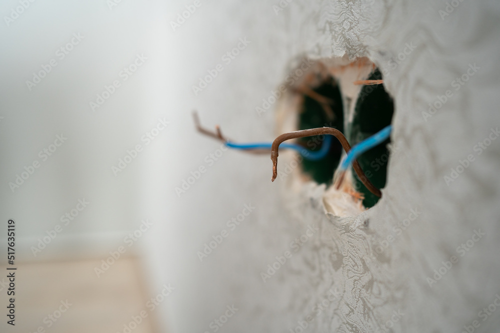 Several exposed electrical copper wires protruding from a whitewall ...