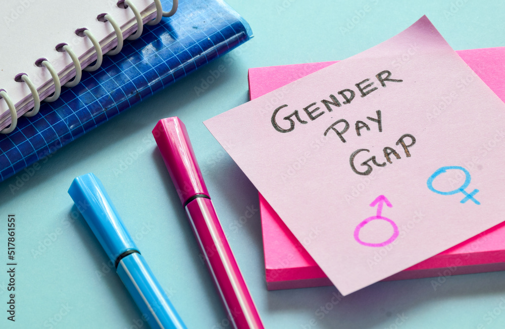 Sticky note with the text Gender pay gap and symbols on desk. Gender ...