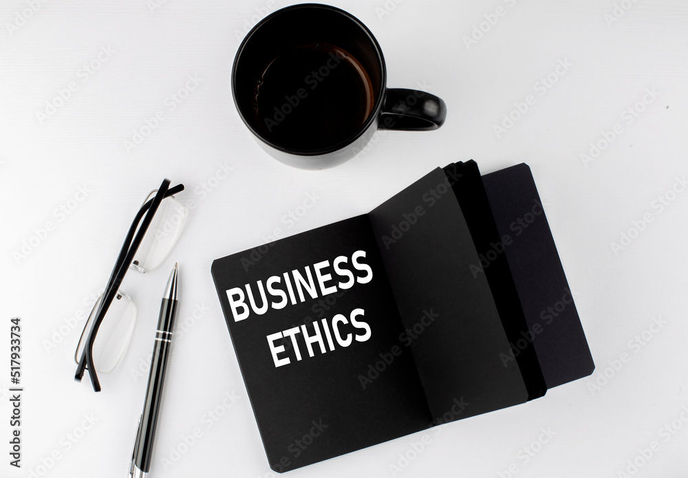 BUSINESS ETHICS written text in small black notebook with coffee , pen ...