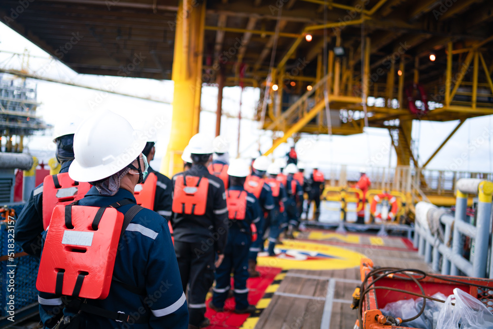 Offshore queuing workers work on decks during disembarkation operations ...