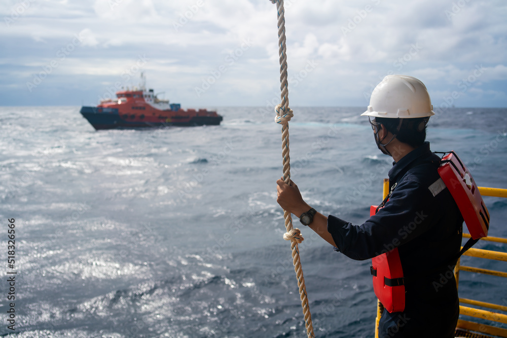 Offshore queuing workers work on decks during disembarkation operations ...