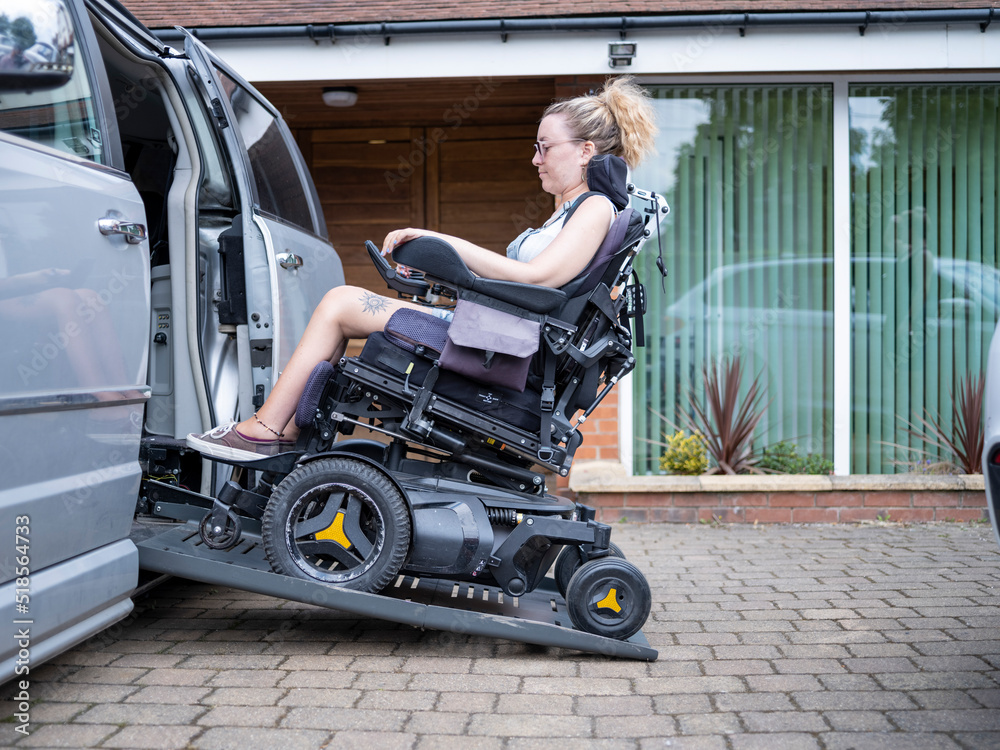 Photo Stock Woman in electric wheelchair getting in van Adobe Stock