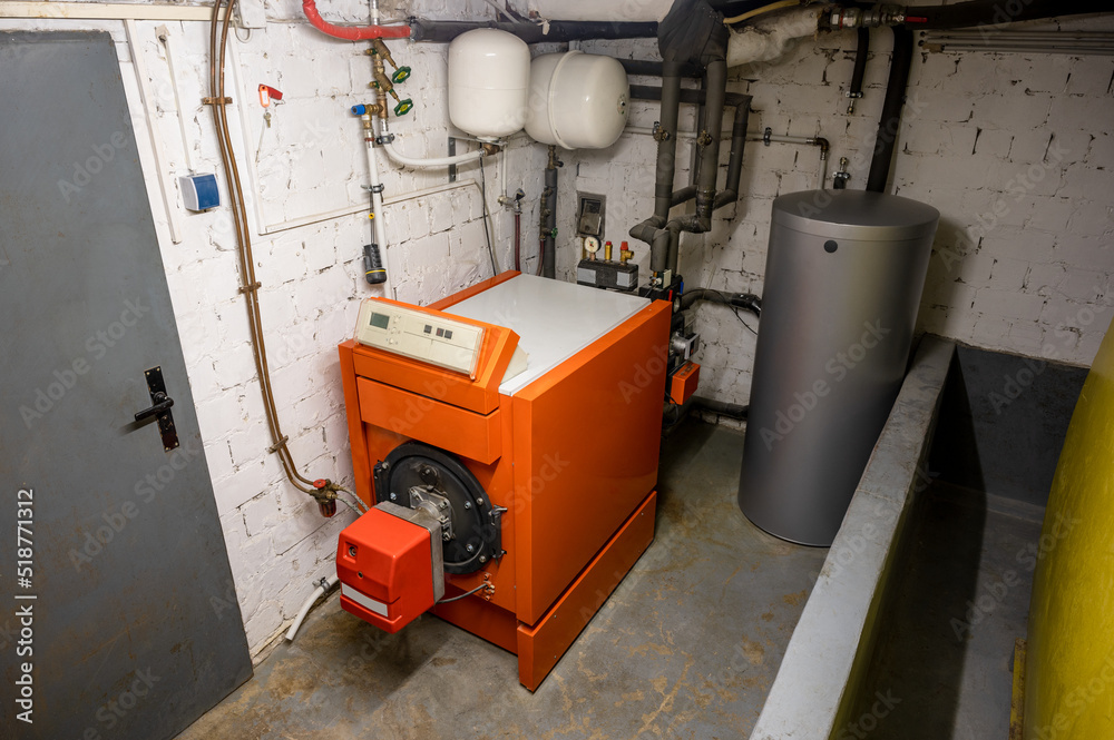 Old oil heating system with oil tank and hot water tank in the basement ...