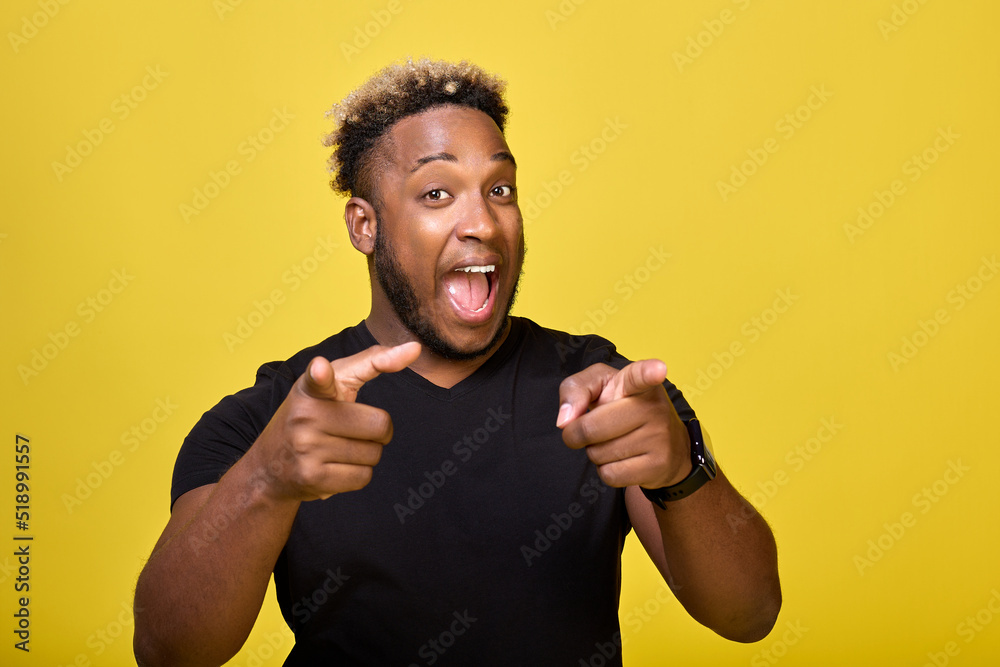 Happy young man with a smartwatch points his index finger at the camera ...