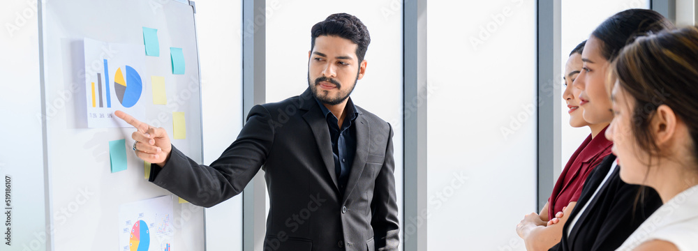 Businessman pointing towards graph and giving Flipchart presentation ...