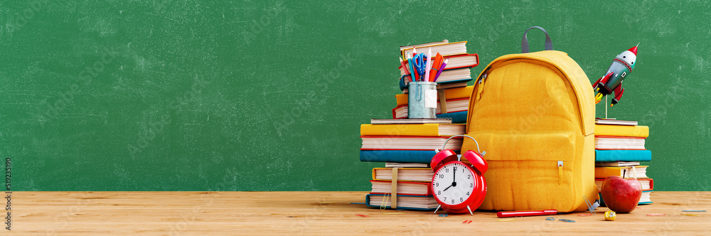 Yellow school bag with books and accessory on empty green chalkboard ...