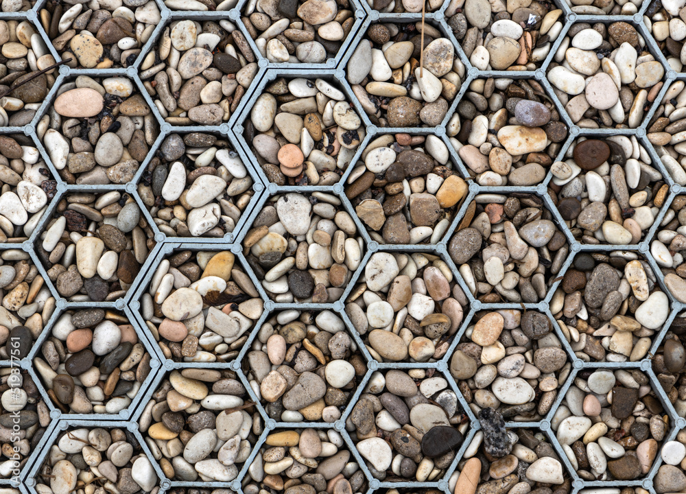 Pebble stones in ground reinforcement grid. Texture of pebble stones ...