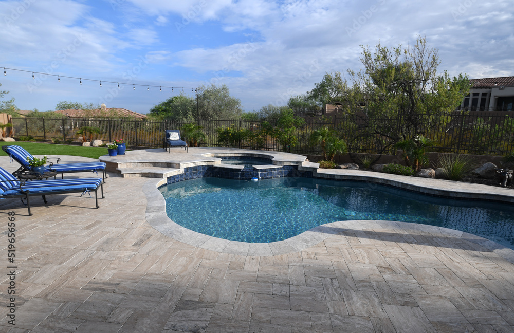 A desert landscaped backyard in Arizona featuring a travertine tiled ...