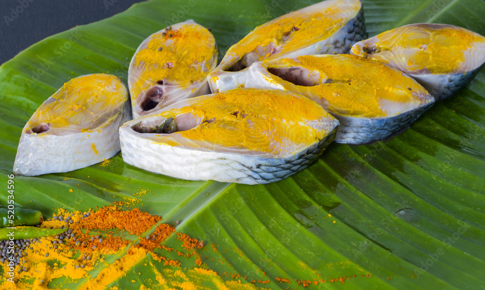 Raw hilsa fish cut into pieces kept on banana leaf for cooking. Shot ...