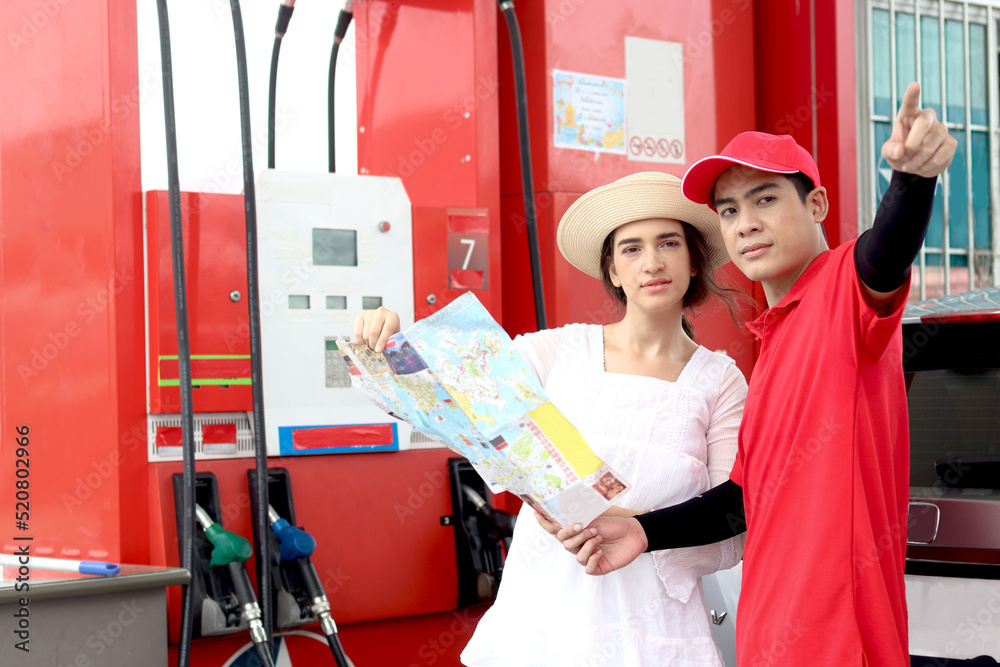 Beautiful woman traveler holding touristic map while asking gas station ...