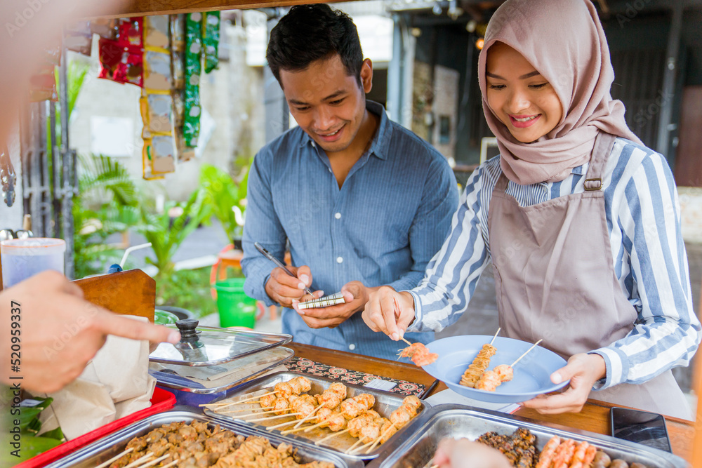muslim couple ordering food to break fasting in traditional food market ...