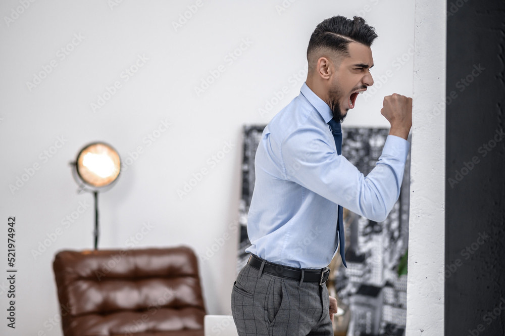 Angry man touching wall with his fist Stock Photo | Adobe Stock