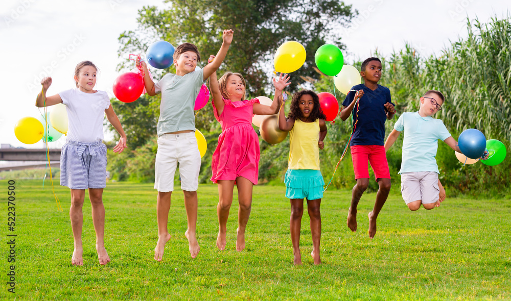 Multiracial group of cheerful emotional preteen friends gaily spending ...