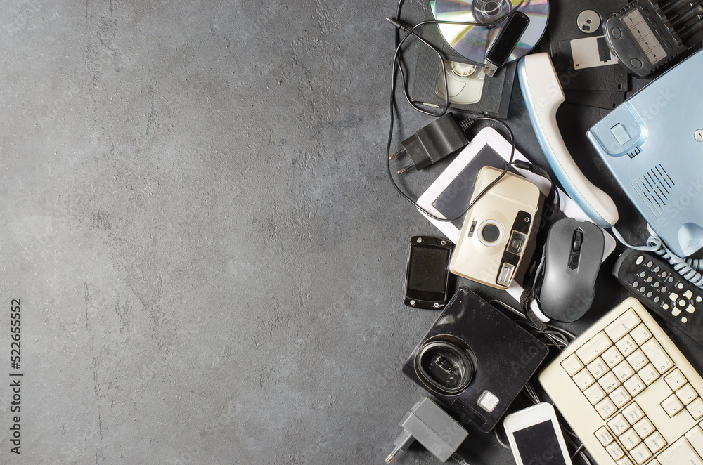 Old electronic devices on a dark background. The concept of recycling ...