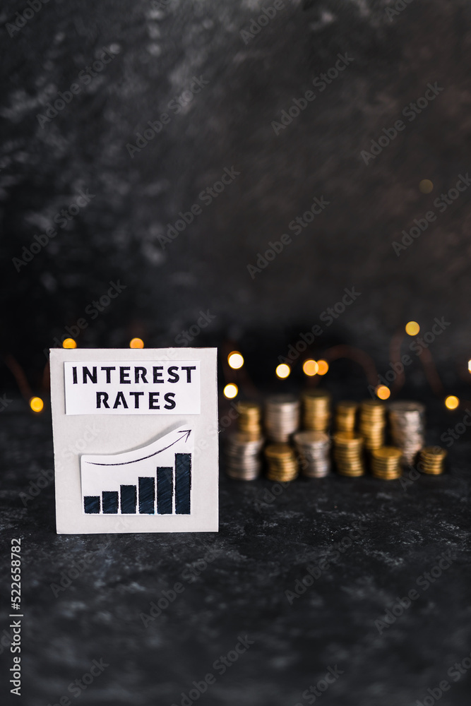 interest rates text and graph showing stats going up in front of stacks ...