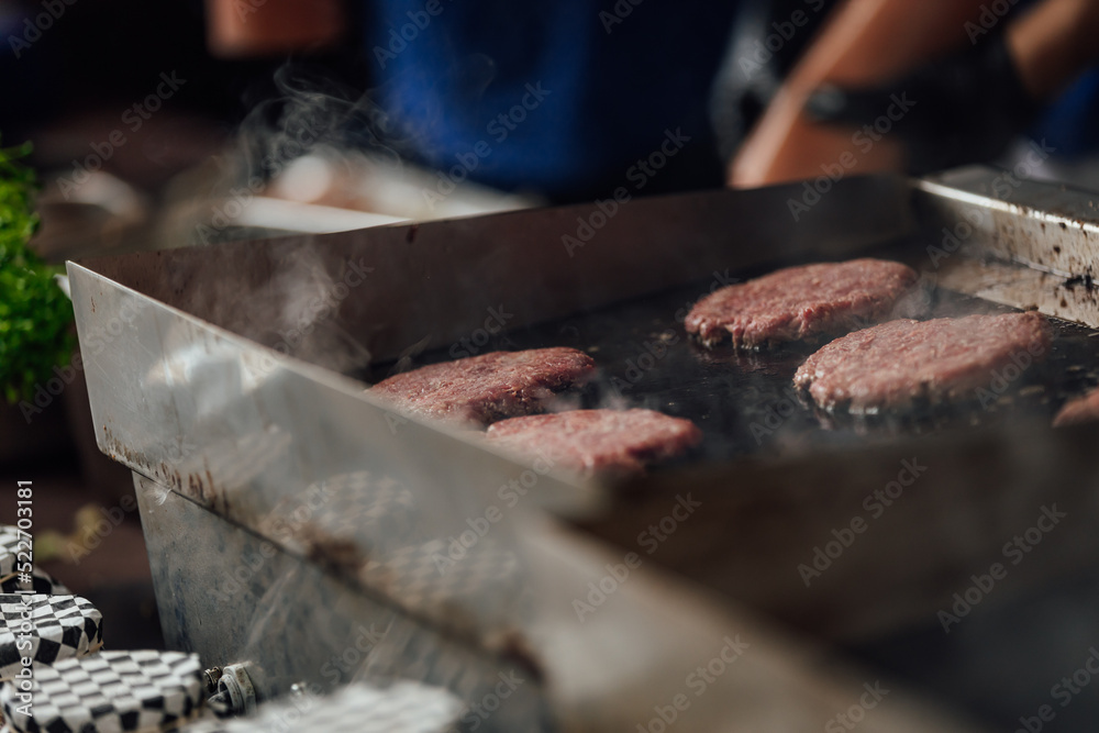 Foto de Stock Chef making burger meat at the open air restaurant grill ...
