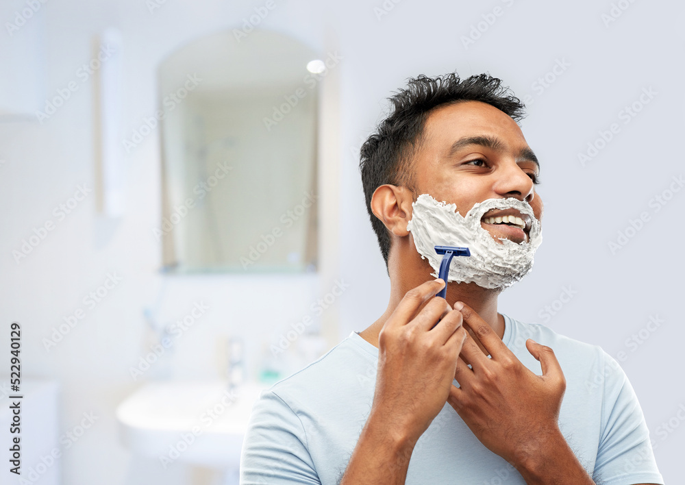 grooming and people concept - man shaving beard with manual razor blade ...