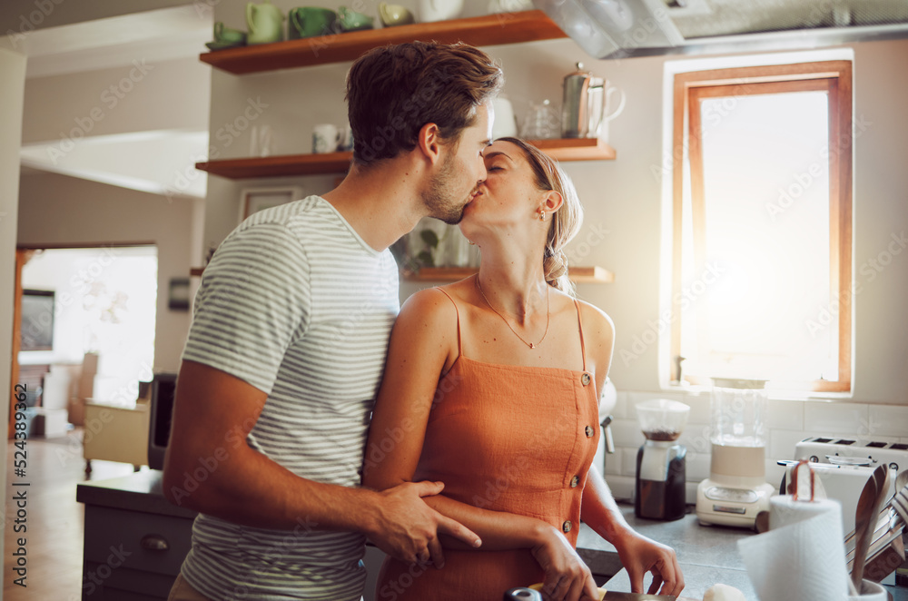 Romantic couple kissing, cooking and showing affection in love while ...