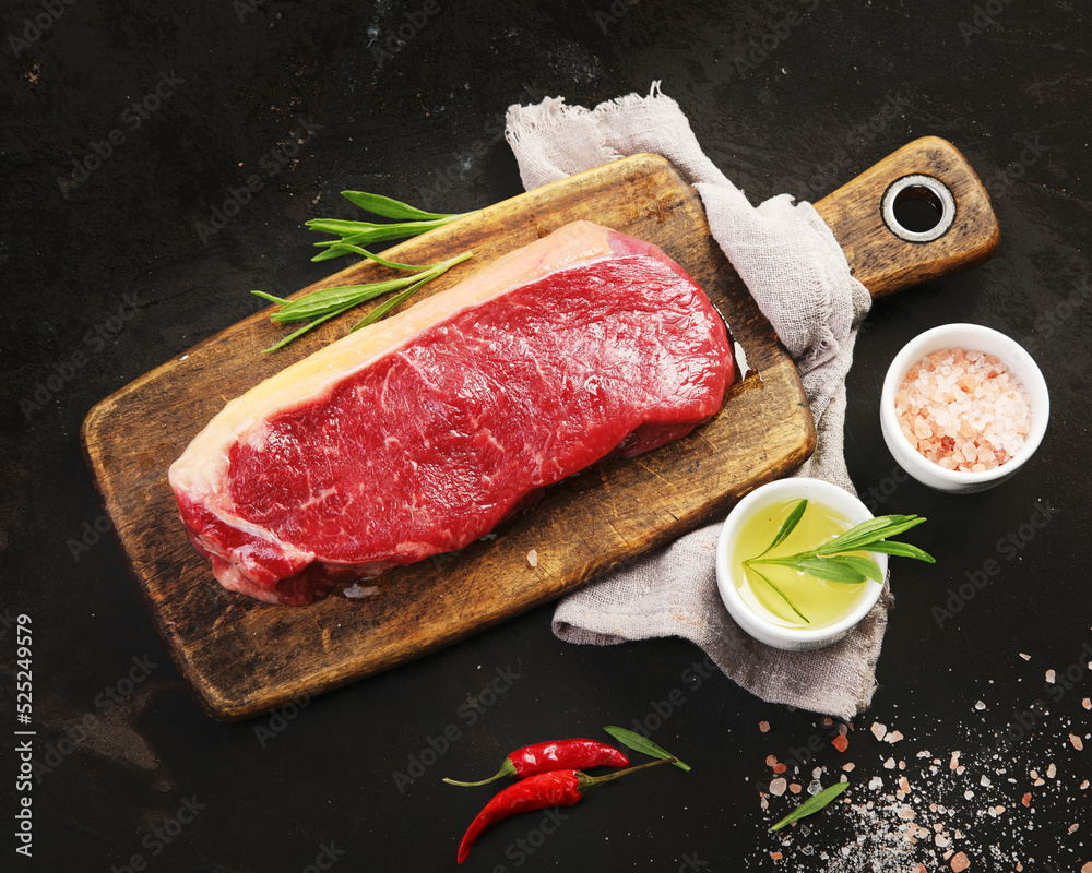 Raw striploin beef steak dark background. Stock Photo | Adobe Stock