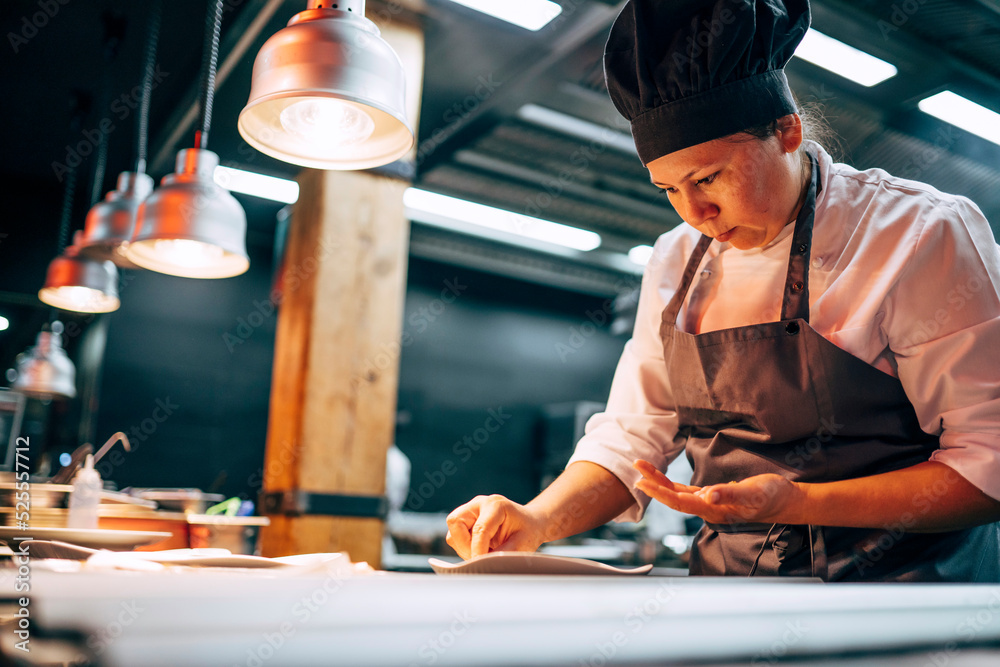 Woman serving dishes in restaurant kitchen Stock Photo | Adobe Stock