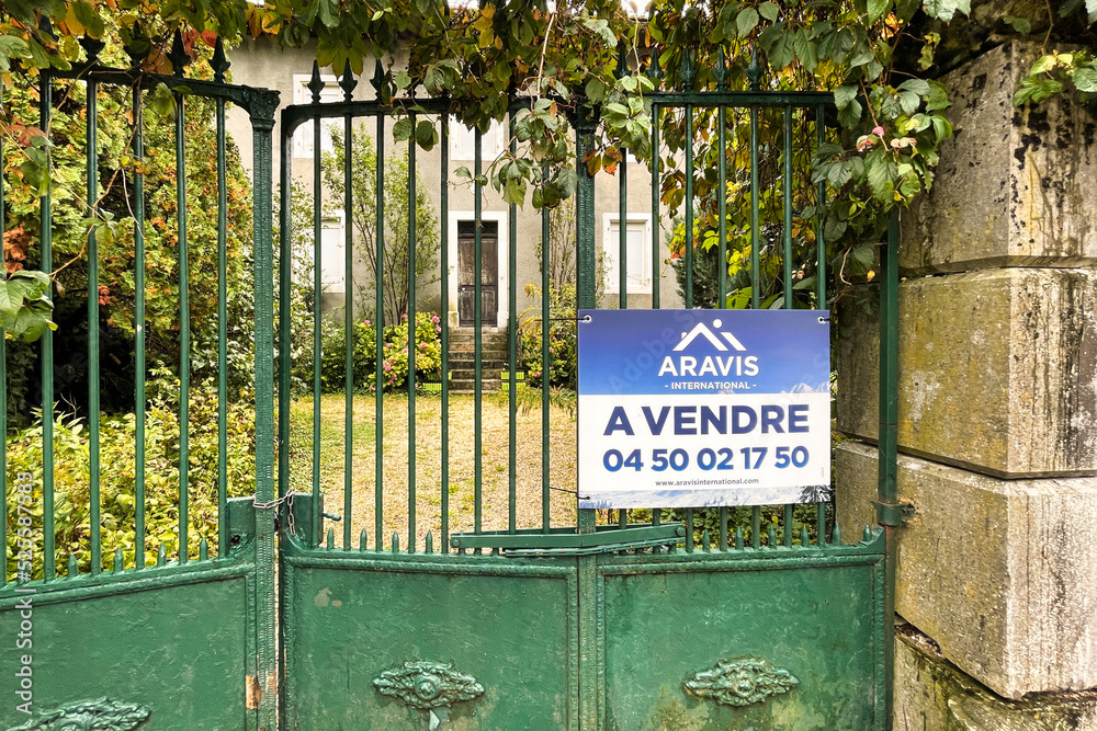 french for sale sign is posted on the green entrance gate of an old ...