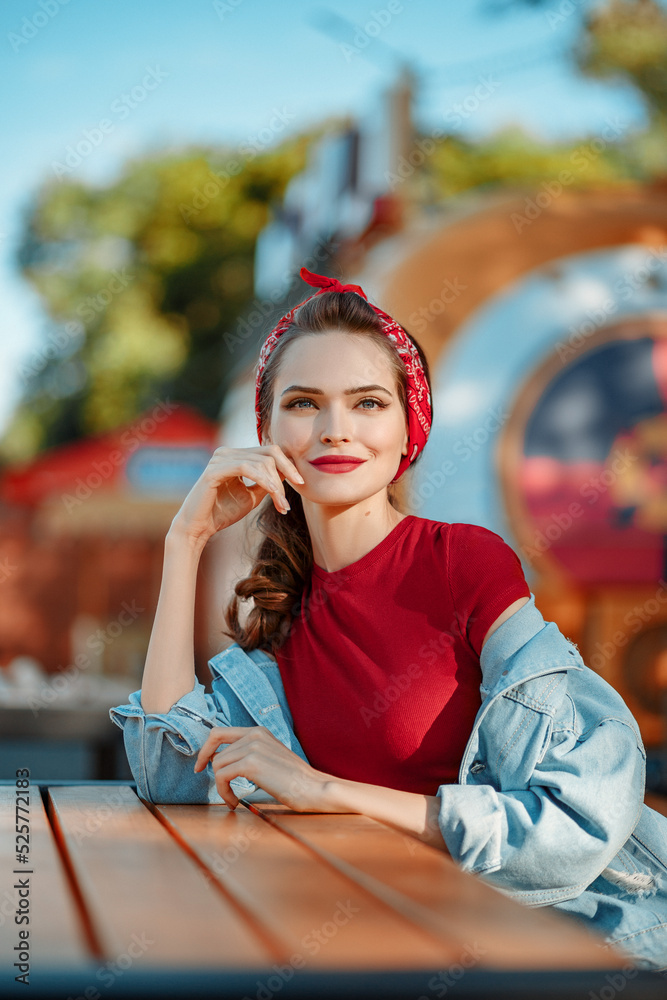 Young beautiful woman in pin-up style clothes posing against the ...
