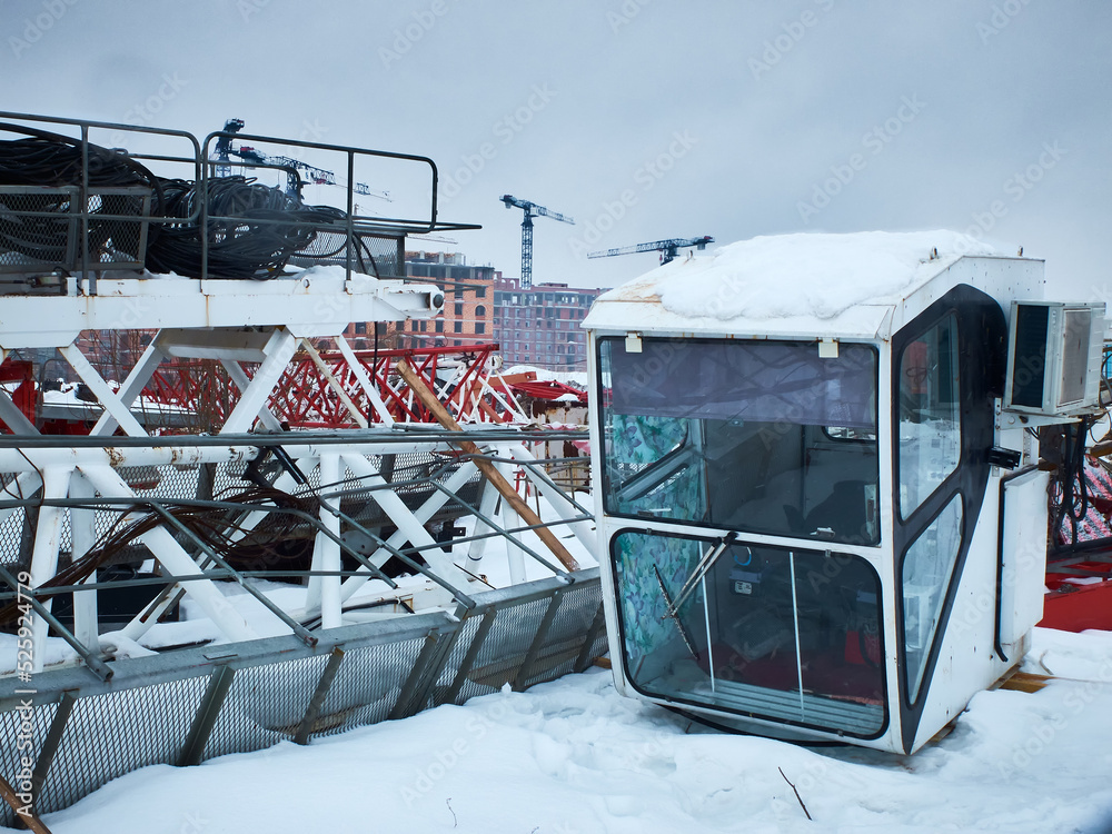 Crane jib and operator booth at construction site covered with snow ...