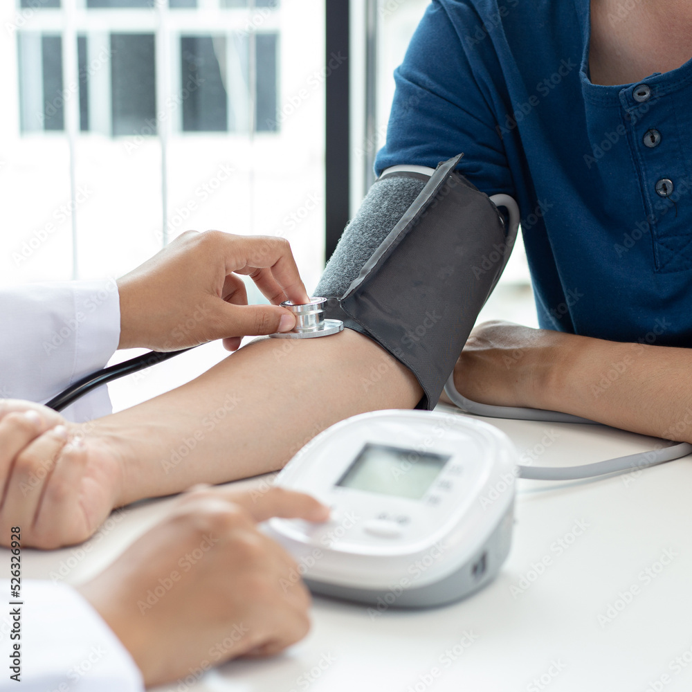 Female doctors use blood pressure monitors and stethoscope to measure ...