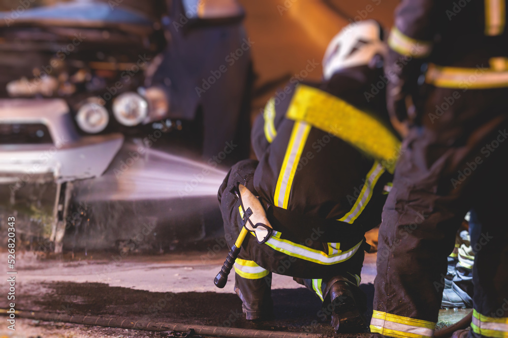 Group of fire men extinguishing and put out burning car crash after ...