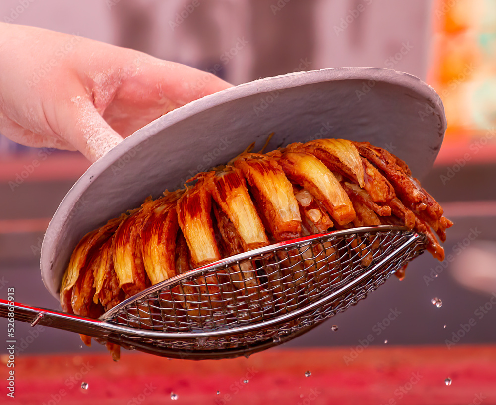 Depp fried onion coming out of the frying oil Stock Photo | Adobe Stock