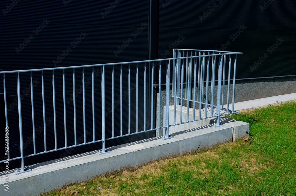 galvanized metal railings at a gray sheet metal industrial hall ...