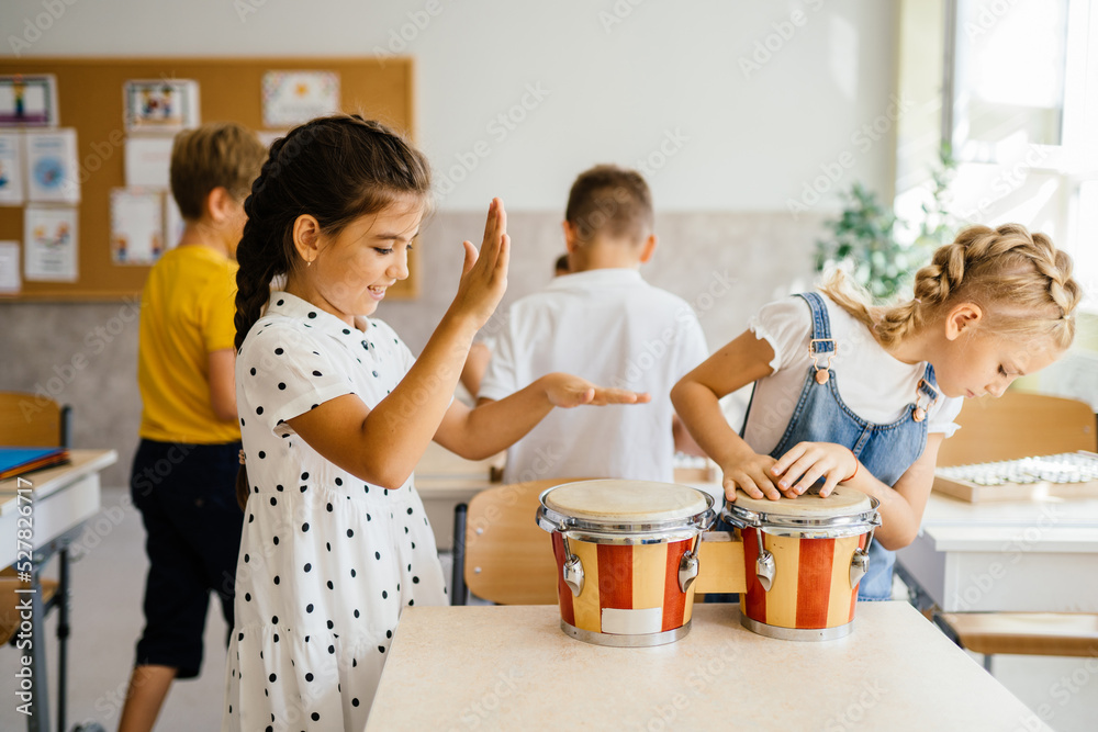 Group of excited children in the music class. Two cute little pupils ...