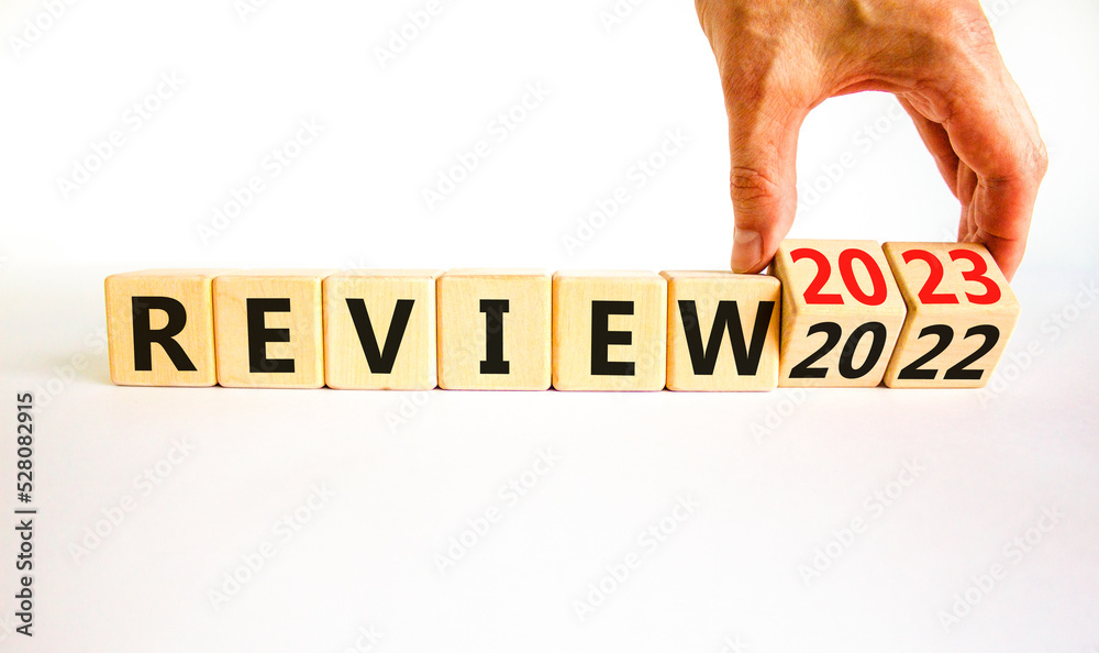 2023 review new year symbol. Businessman turns a wooden cube and ...