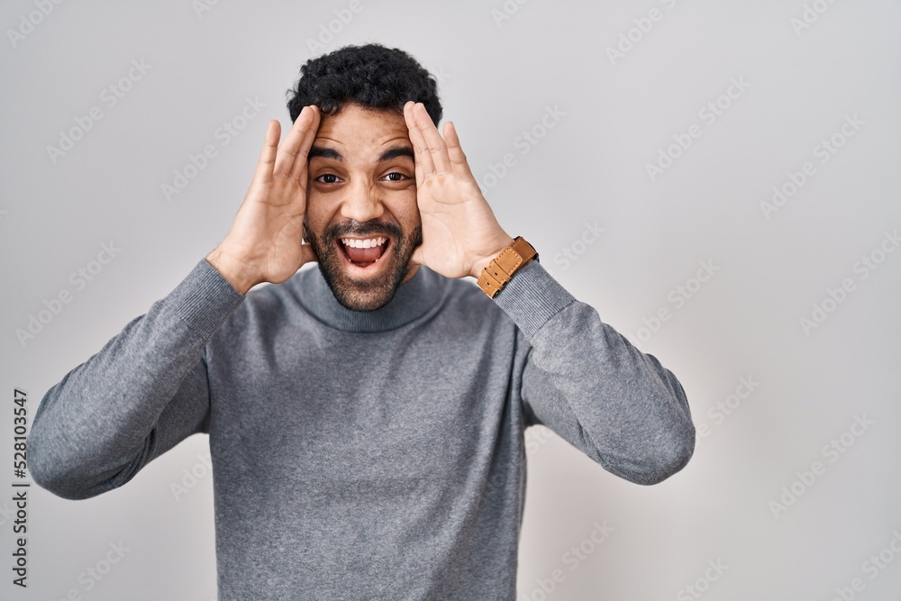 Hispanic man with beard standing over white background smiling cheerful ...