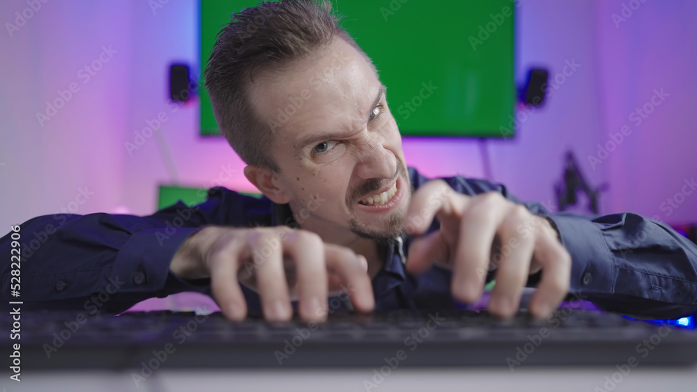 Crazy male person faces while typing with rage on computer from ...