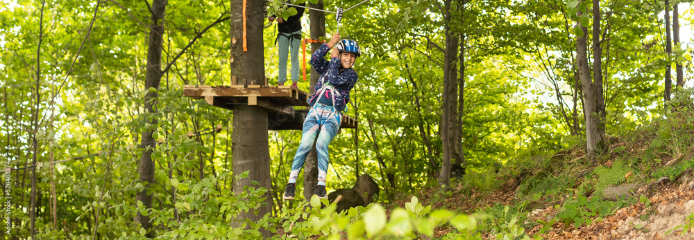 Little girl preschooler wearing full climbing harness having fun time ...