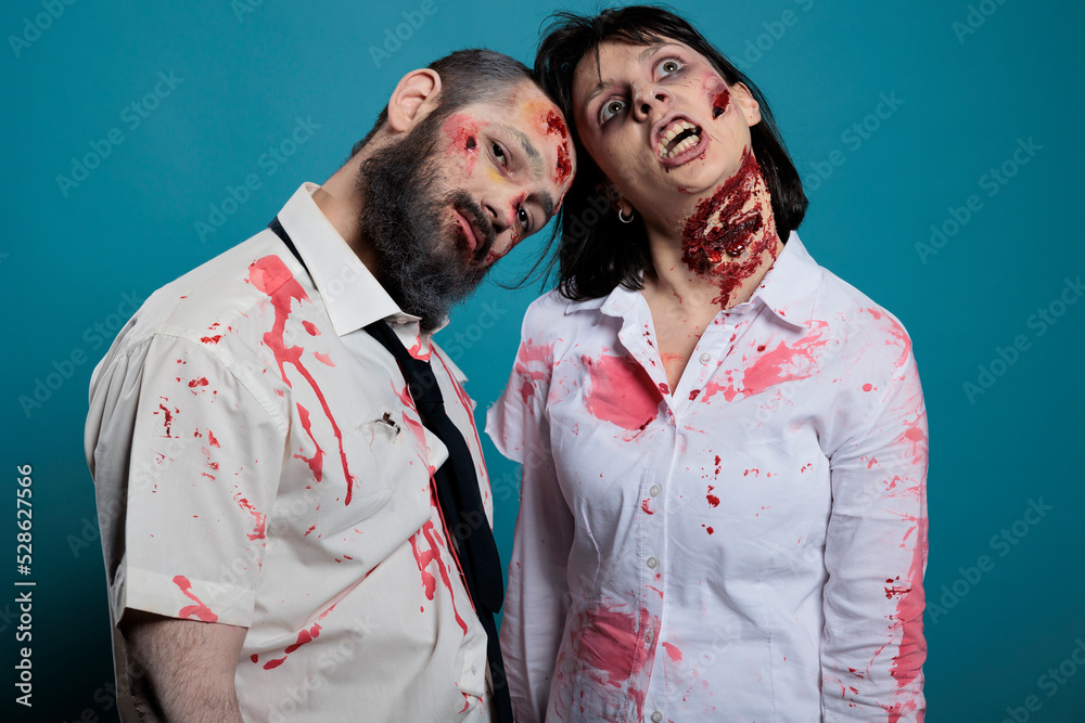 Portrait of zombies couple posing on camera, looking undead and creepy ...