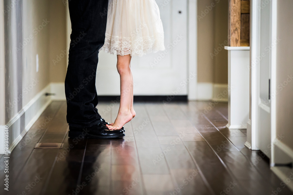 Low section of girl tiptoeing on father's feet at home Stock Photo ...