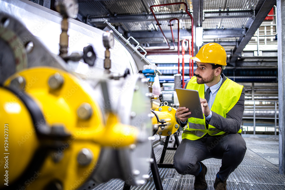 Oil and gas production manager or supervisor with digital tablet ...