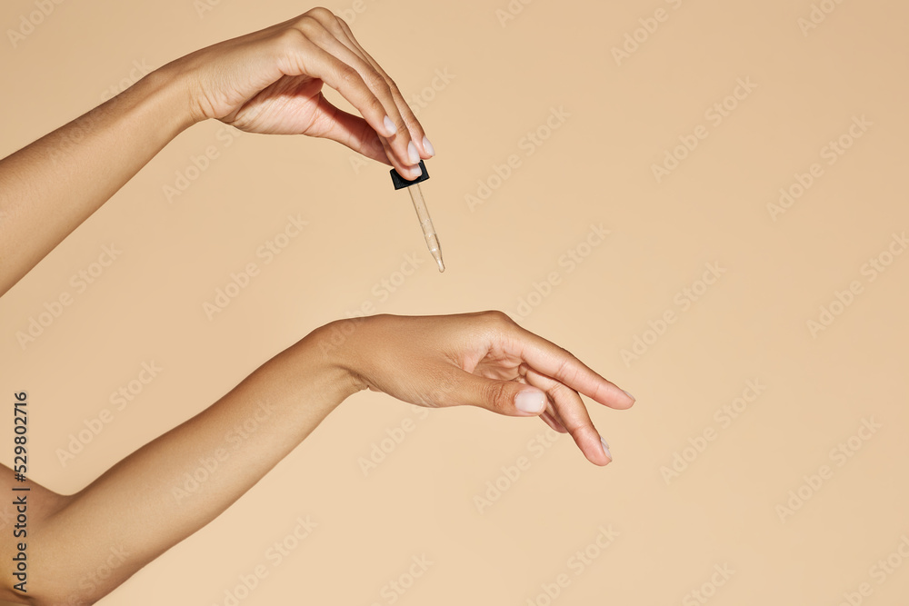 Moisturizing skin of hands with essential oil or serum. Woman applying ...