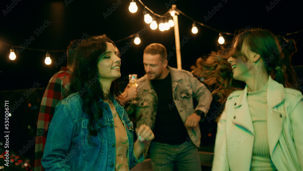 Excited group of friends have fun time on the rooftop of terrace they ...