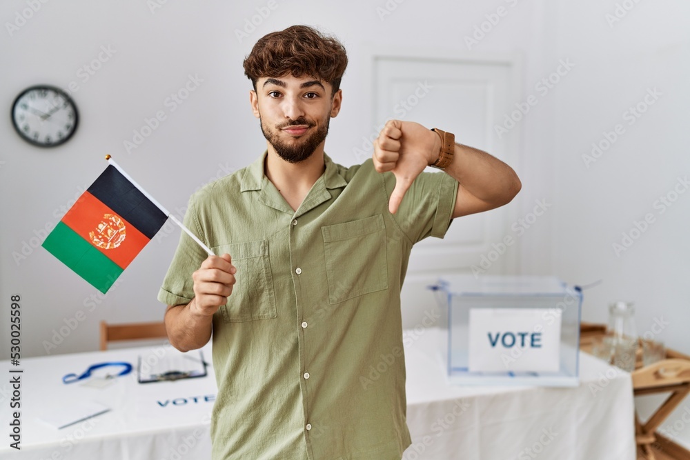 Young arab man at political campaign election holding afghanistan flag ...