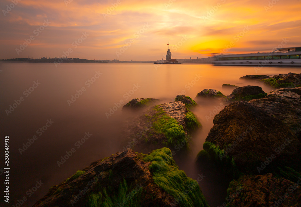 Fiery sunset over Bosphorus with famous Maiden's Tower (Kiz Kulesi ...