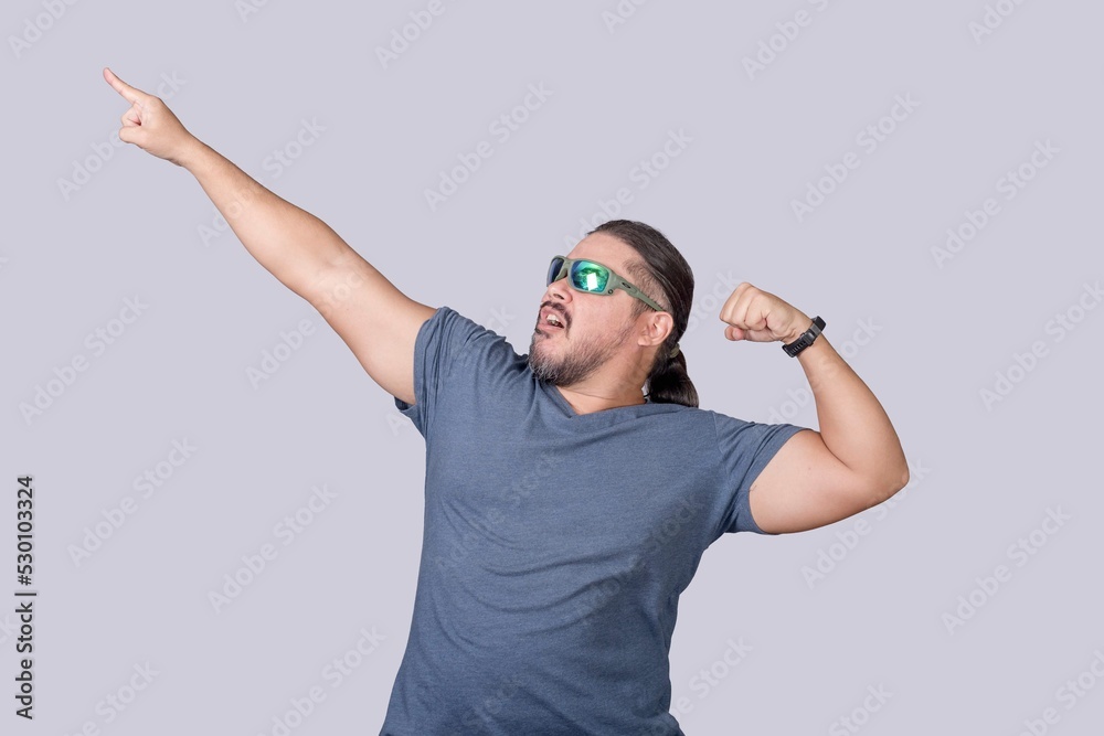 An exuberant and wild man poses pointing up while flexing his arms. A ...